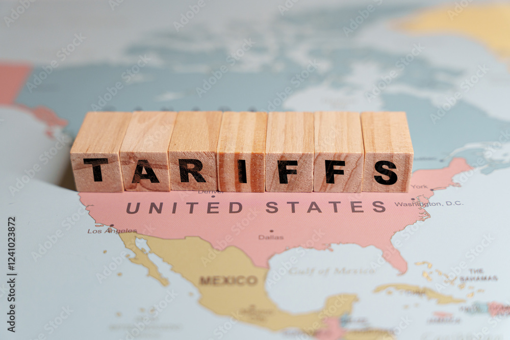 Wooden blocks spelling TARIFFS are placed on a map of North America ...