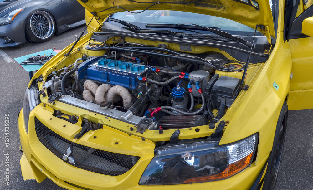 Hood is raised revealing engine bay of Mitsubishi Lancer Evolution with ...