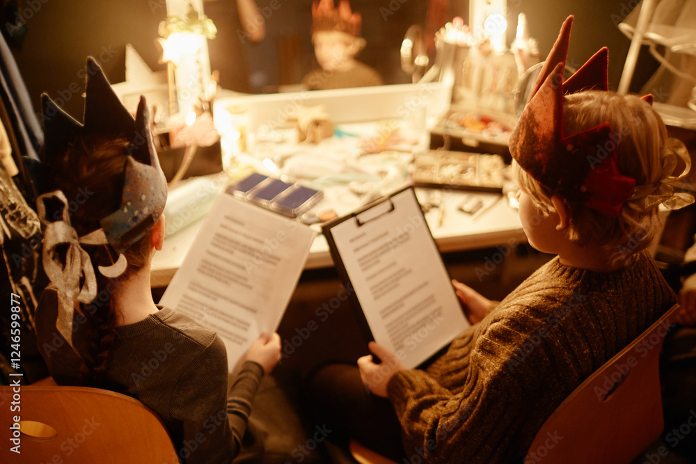 Children wearing crowns rehearsing scripts in classroom setting ...