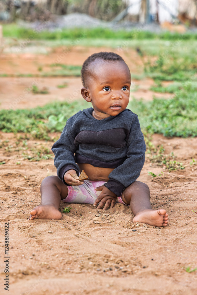 African village, single African hungry baby child , sitting in the yard ...