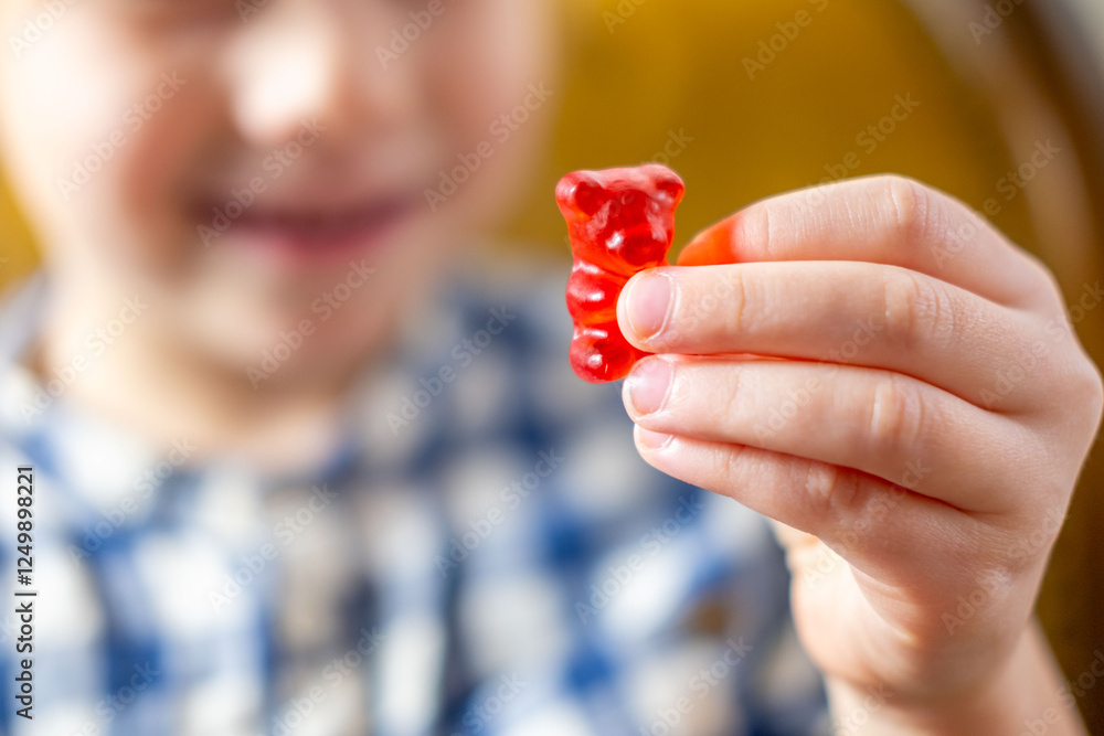 small child, girl 5 years old wants eat gelatinous sweets, gummy bear ...