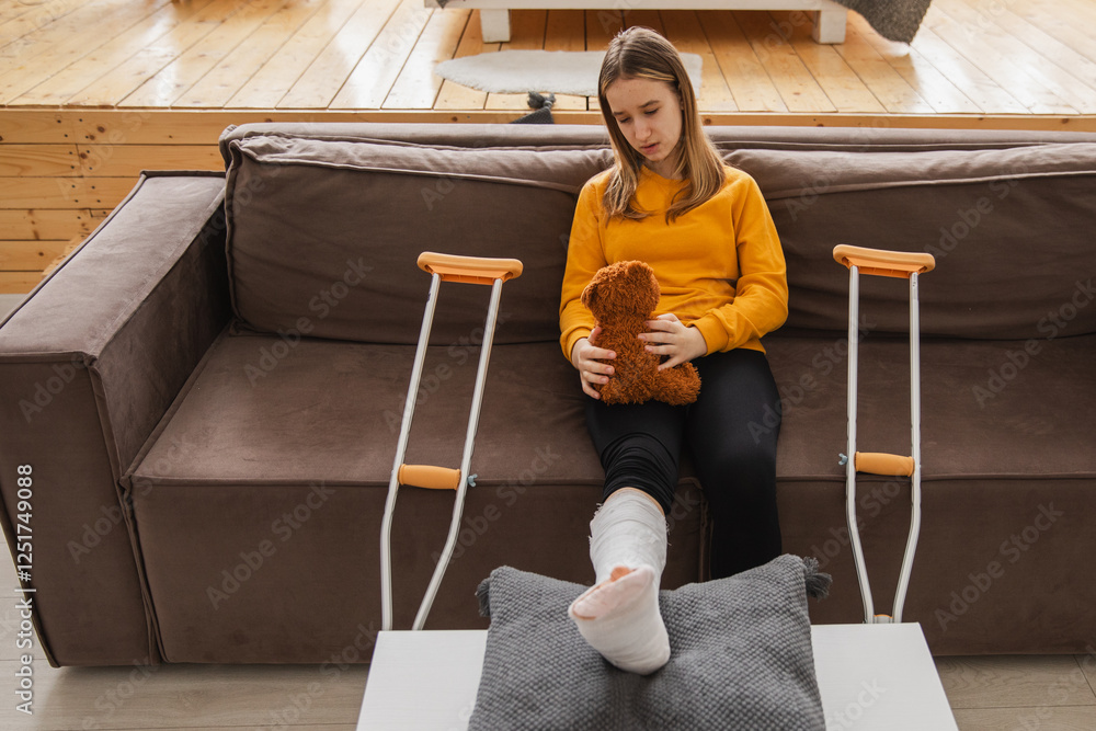Stock-Foto „Young girl with broken leg cast sitting on sofa. Sad little ...