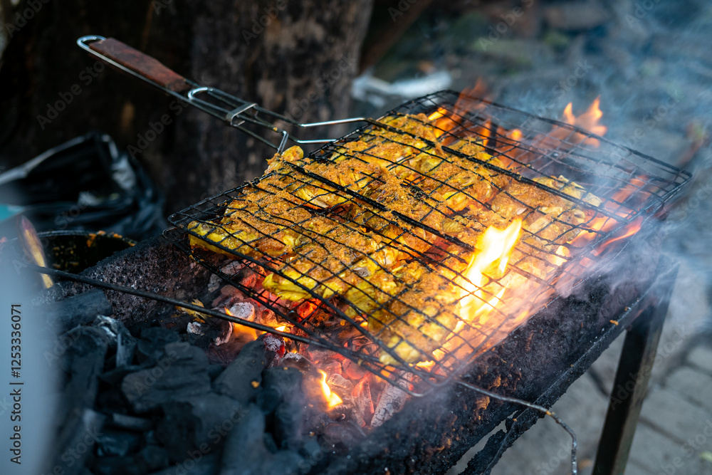 Man grilling chicken over charcoal at a food stall (warung), delicious ...