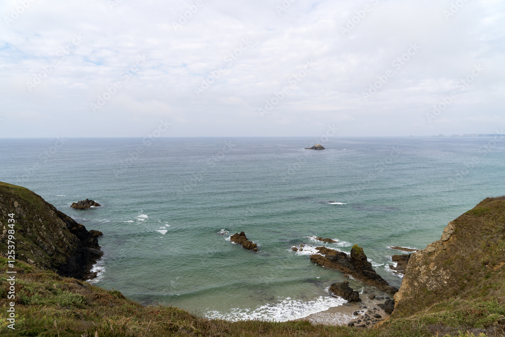 Fotografie Pointe rocheuse battue par les vents et les vagues, entourée ...