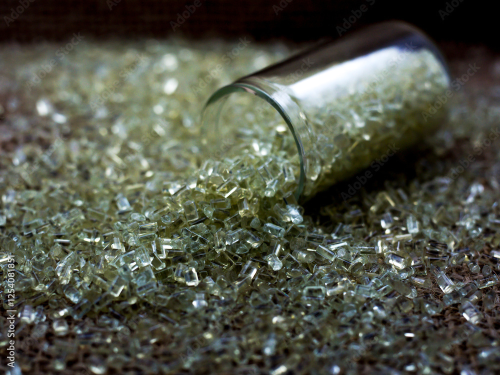 Natural colored polycarbonate plastic granules with glass tube, one of ...