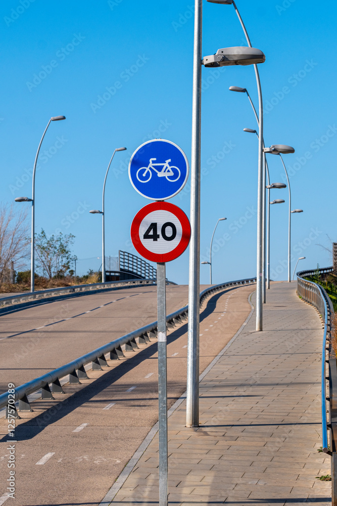 Bike lane and speed limit signs on a wide urban road with clear skies ...