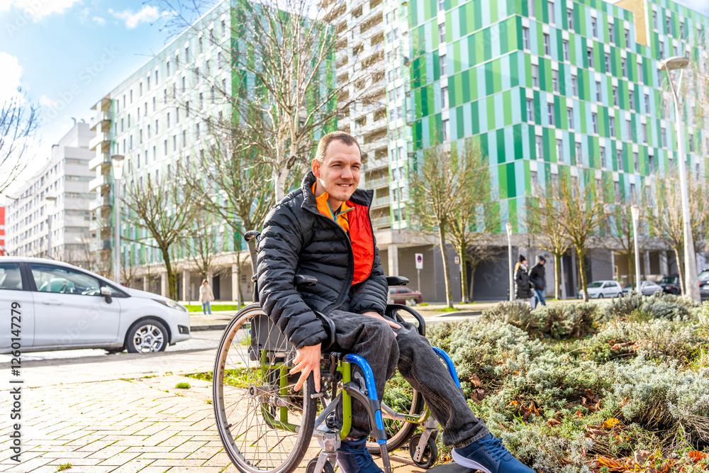 Young disabled man smiling in wheelchair near modern buildings Stock ...