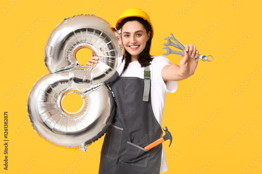 Portrait of young female construction worker with balloon in shape of ...