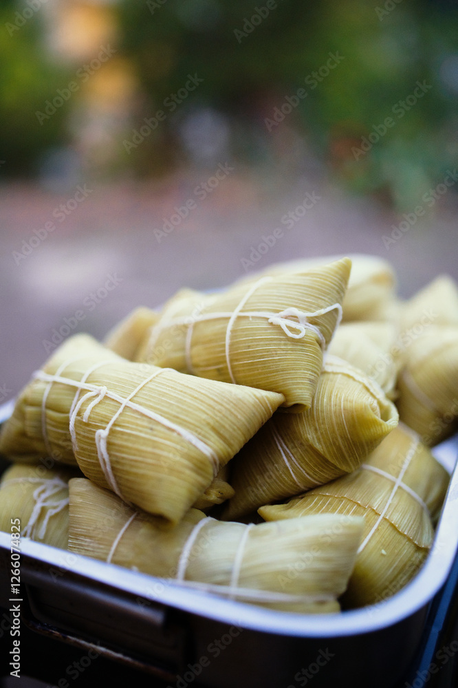 Photographs of a person preparing humitas using choclos, corn on the ...