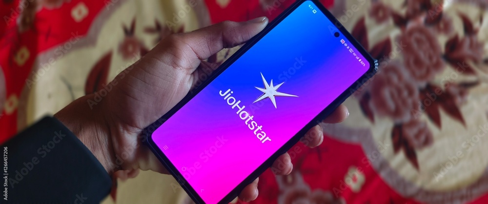 New Delhi, India - February 15 2025. Jio hotstar app icon on mobile screen, a person using ...