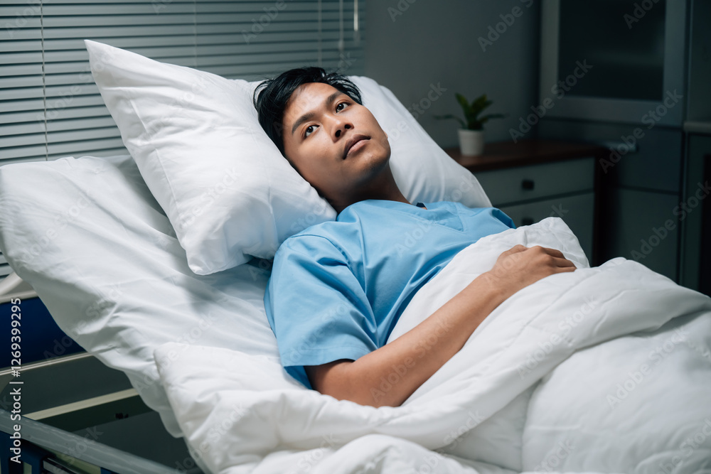 Male patient recovering in hospital bed, looking upward with hopeful ...
