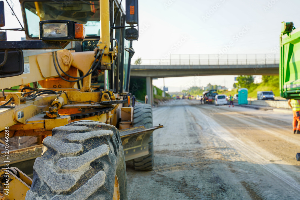 Motor grader in action on a highway construction site, showcasing ...
