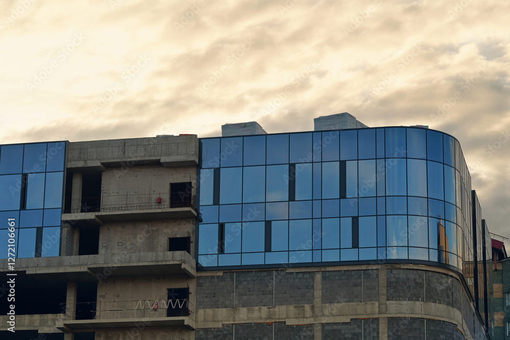 Building under construction with glass facade installation. High-rise ...