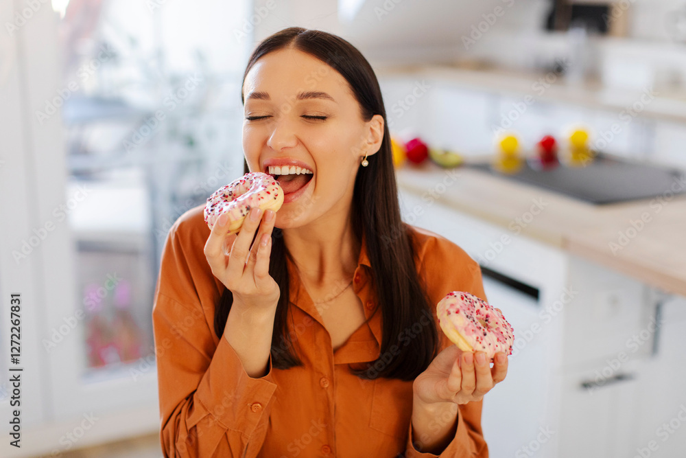 Cheat meal. Hungry woman biting donuts, eating junk food at home ...