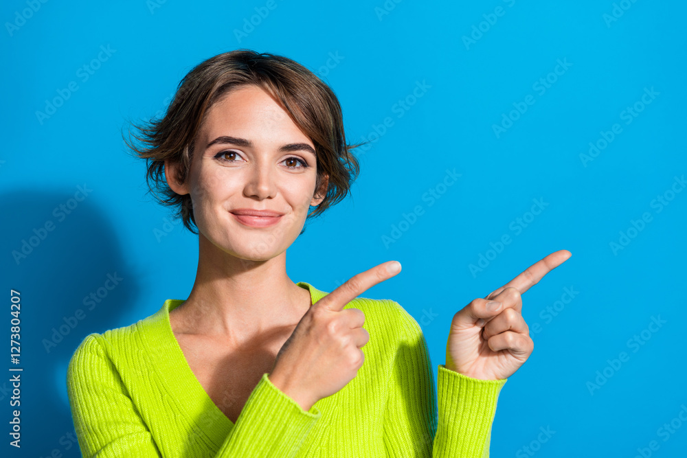 Portrait of lovely friendly girl indicate fingers empty space ...