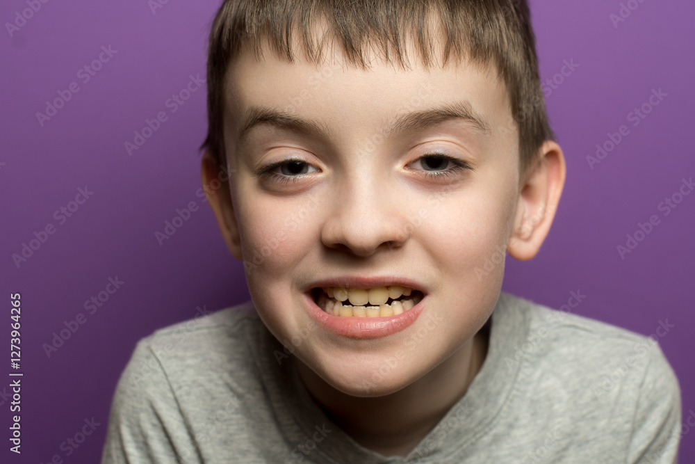 Child with missing teeth smiling, purple background. Perfect for themes ...