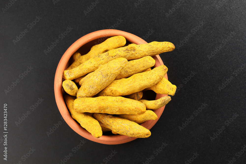 Aromatic turmeric raw roots in terracotta bowl Stock Photo | Adobe Stock