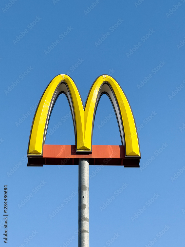 Golden arches logo against a clear blue sky representing fast food ...