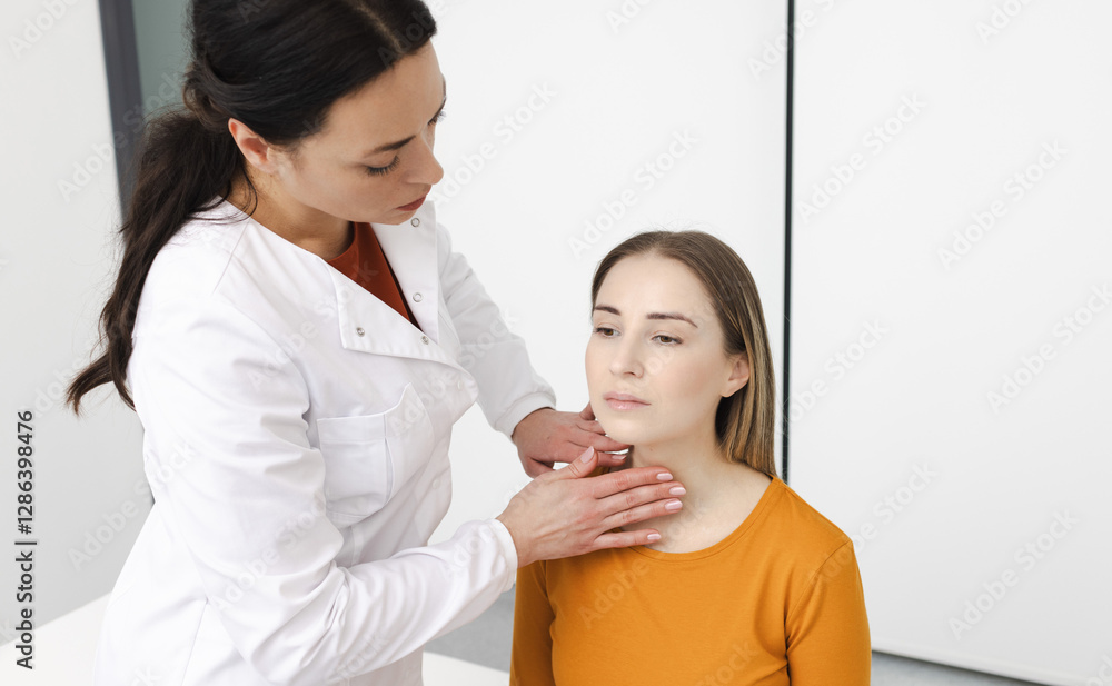 Thyroid gland exam and treatment. Doctor palpates of woman's neck for ...
