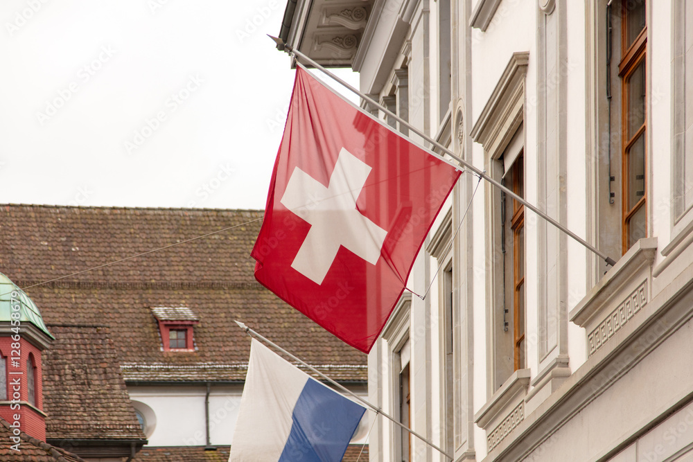 Swiss flag hanging from a pole on a building facade, traditional ...