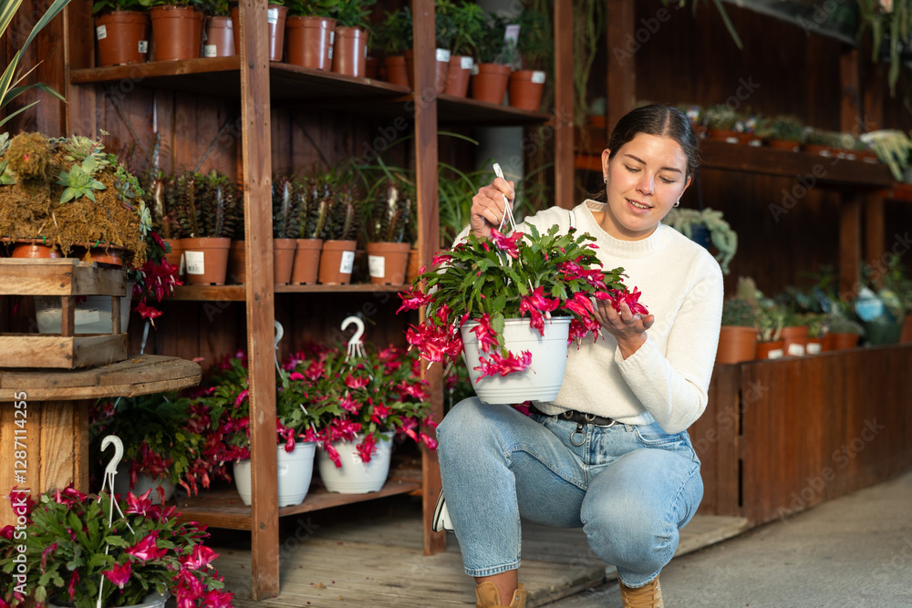 Girl customer with product in hands at fair chooses potted plant to ...