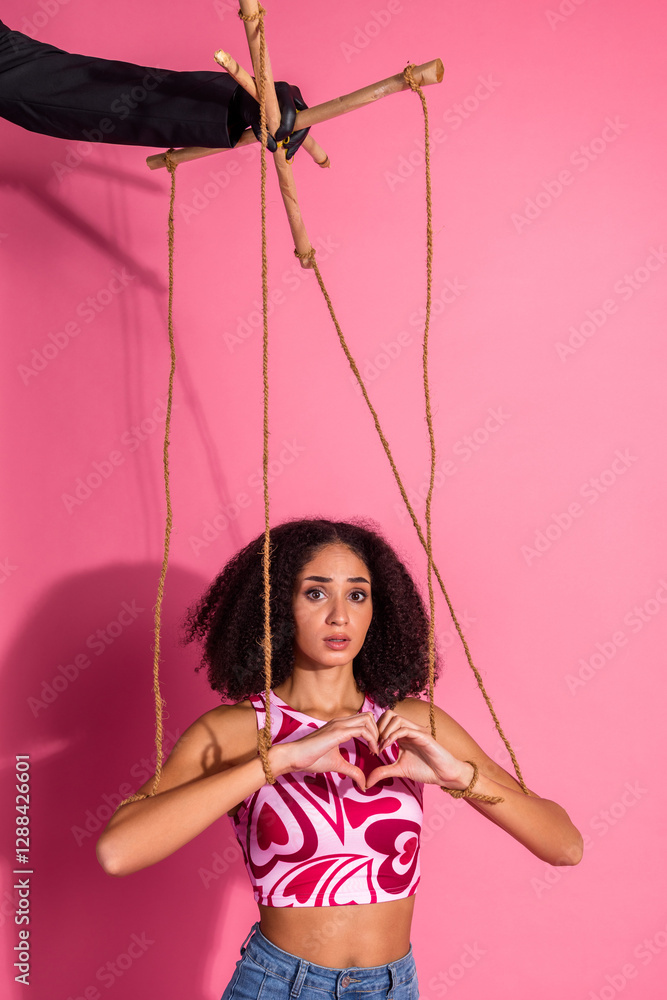 Stylish young woman with curly hair posing against pink vertical ...