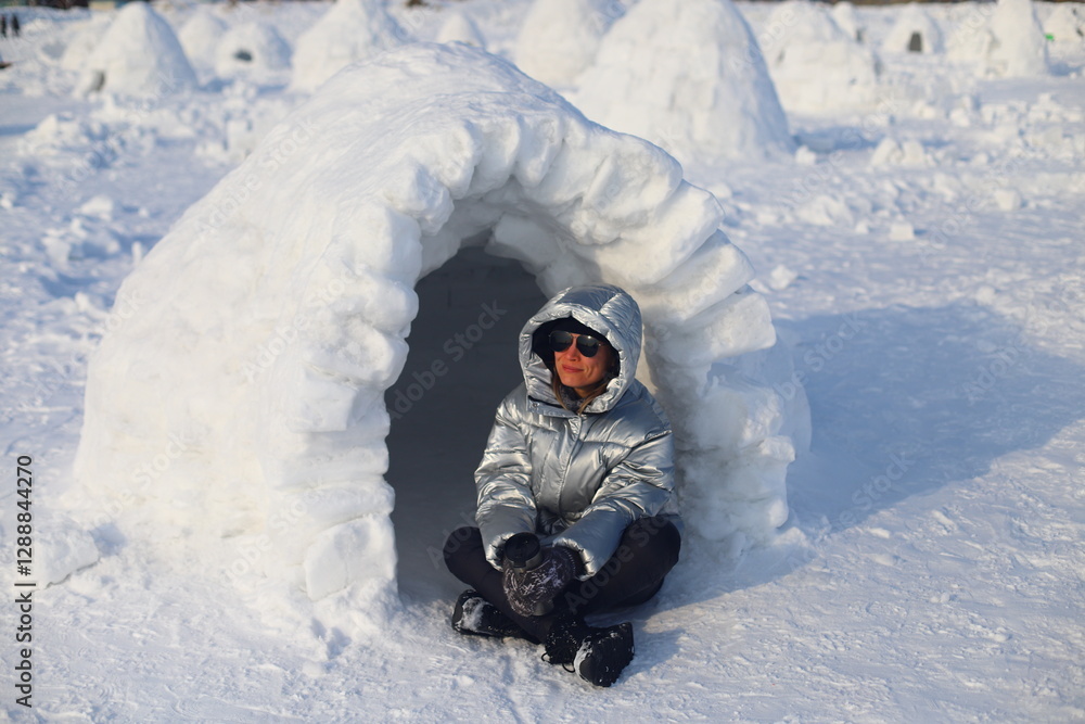 Adult happy woman relaxing on picnic in Eskimo village. Woman in warm ...