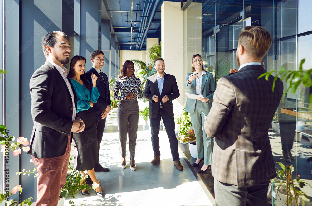 Boss and group of happy business people standing in lobby of modern ...