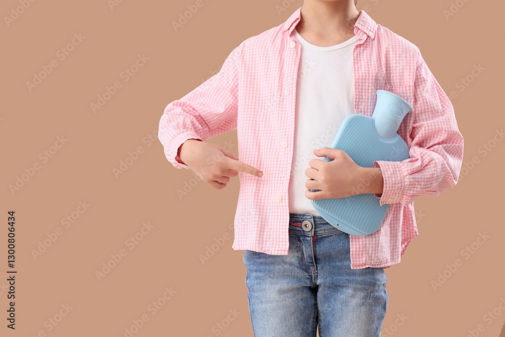 Teenage girl with hot water bottle pointing at appendicitis on beige ...
