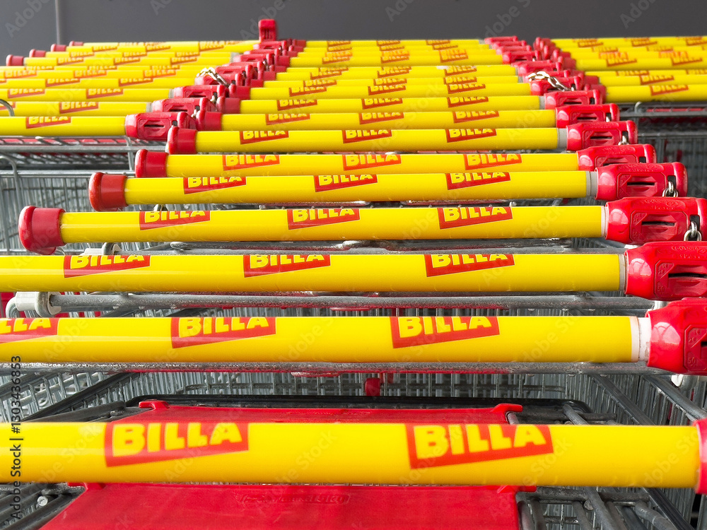 Row of billa shopping carts with red handles in supermarket parking ...