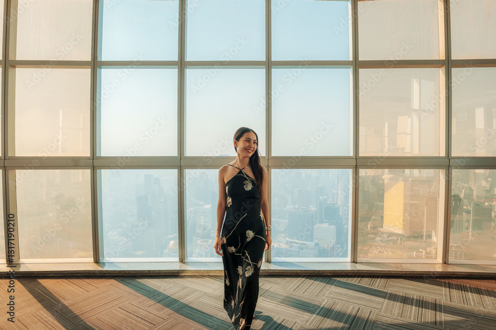 Asian stylish woman enjoying on observation deck and modern glass ...
