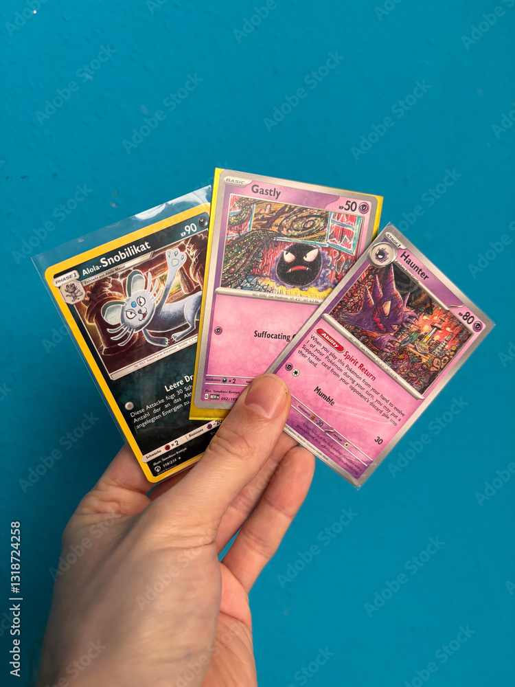 Hamburg, Germany - 03082025: male hand holding three pokemon cards ...