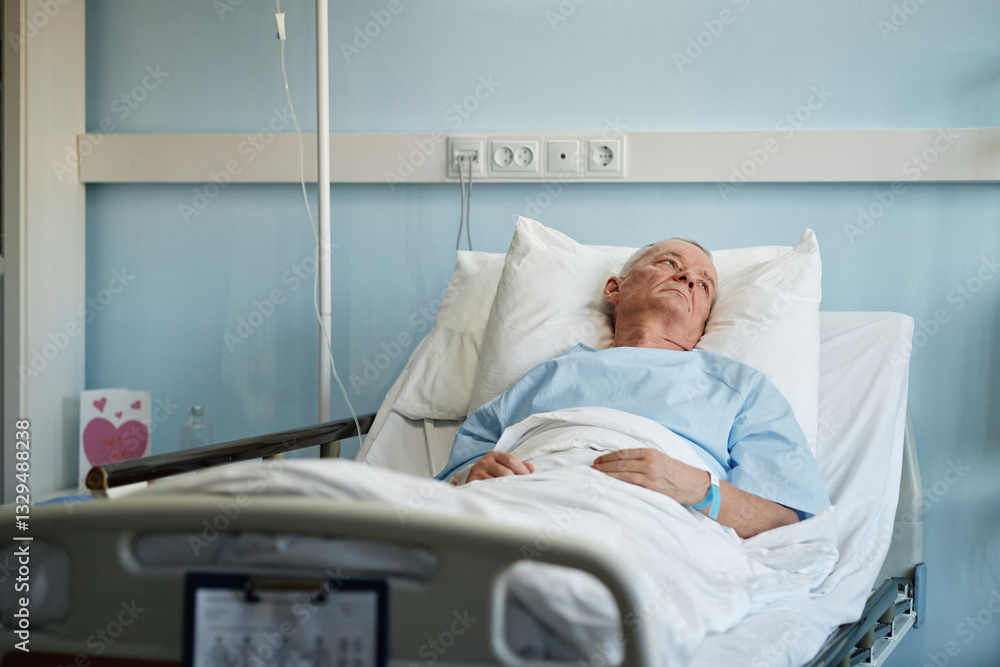 Senior patient resting in hospital bed wearing hospital gown and ...