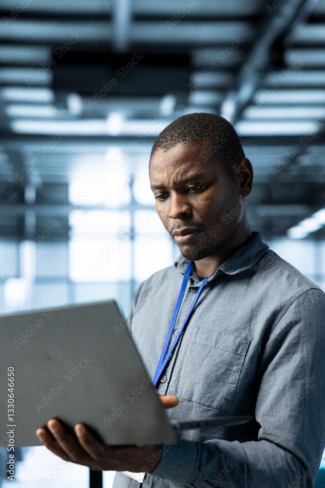 Engineer in data center using laptop, adjusting power management ...