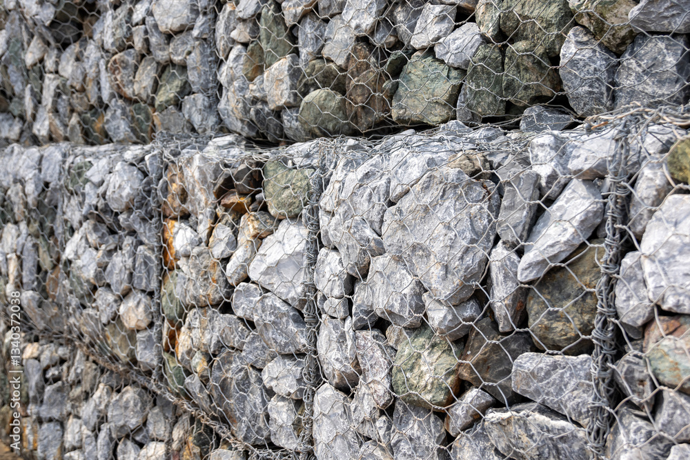 gabion wall, showcasing the texture of the grey stones and the wire ...