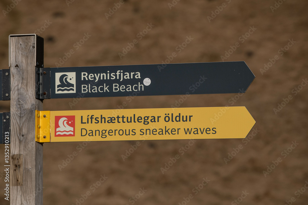 directions and warning sign at Reynisfjara beach in South Iceland, one ...