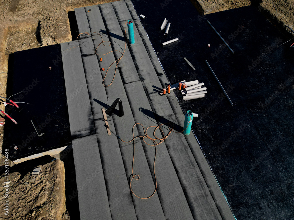 rolls of black asphalt cardboard built side by side. warehouse for roof ...