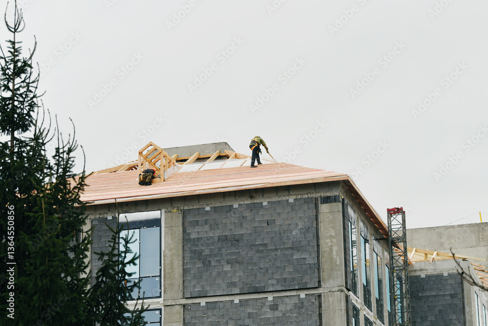Roof construction, workers installing wooden roof boards on new ...