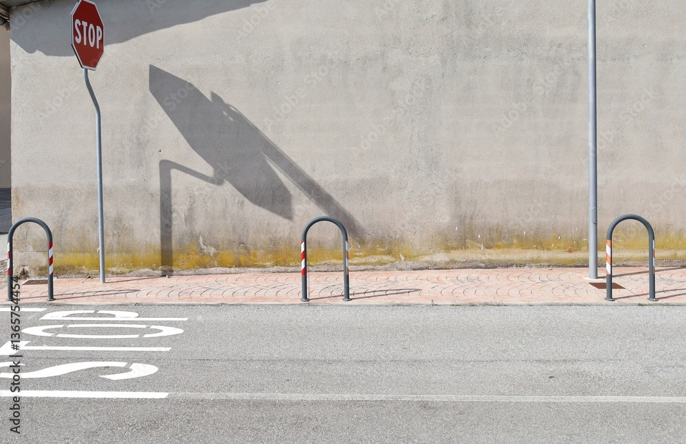 Bollards on sidewalk at the corner of the street. Stop sign on the left ...