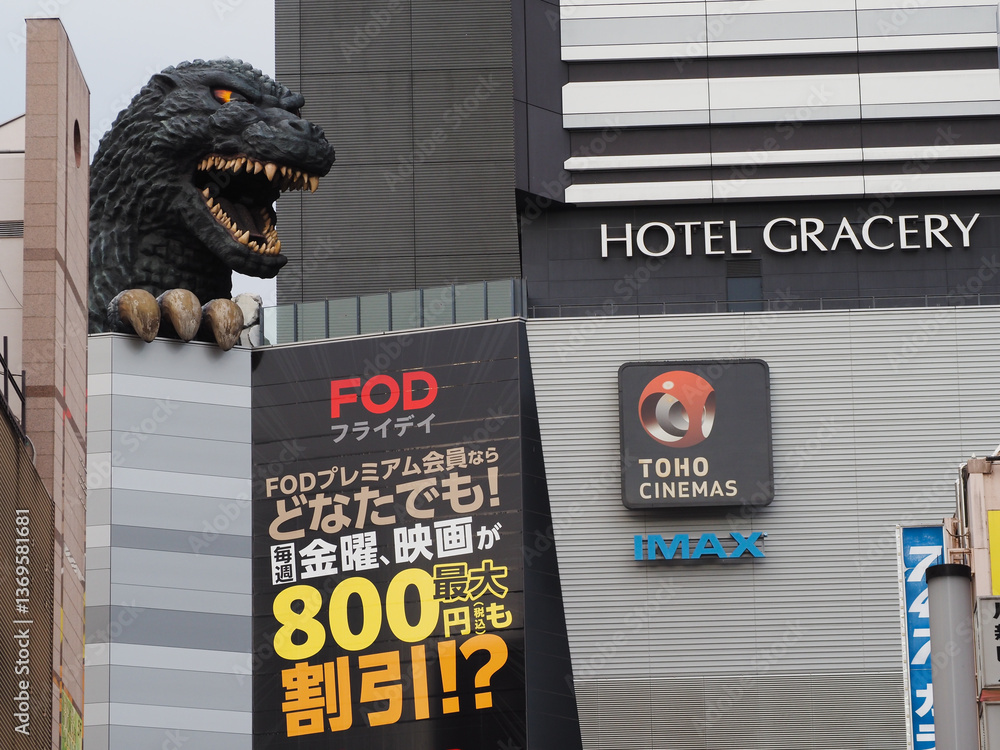 TOKYO, JAPAN - January 7, 2025: Statue of Godzilla on a Toho movie theater in Shinjuku which has ...
