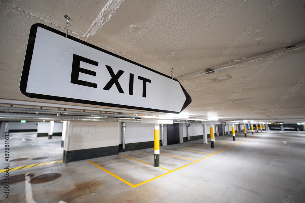 White, large, pointed or directional exit sign inside empty public ...