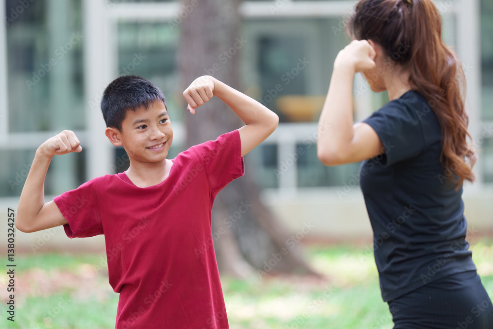Strength Training and Family Fun. A boy flexes his muscles playfully ...