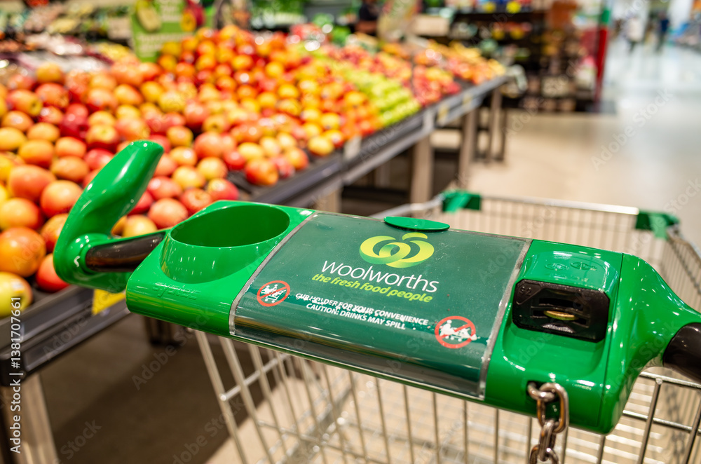 A shopping cart handle with a Woolworths supermarket logo, with a ...