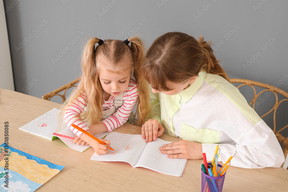 Nanny with cute little girl drawing on table at home Stock Photo ...