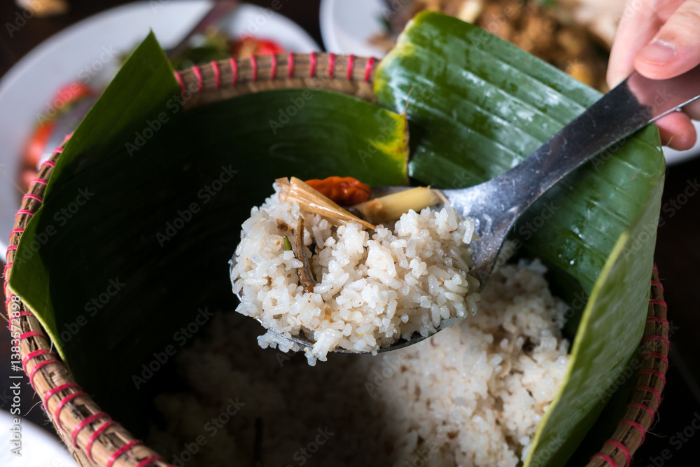 Fragrant Nasi Liwet Sunda on a spoon, revealing rice cooked with herbs ...