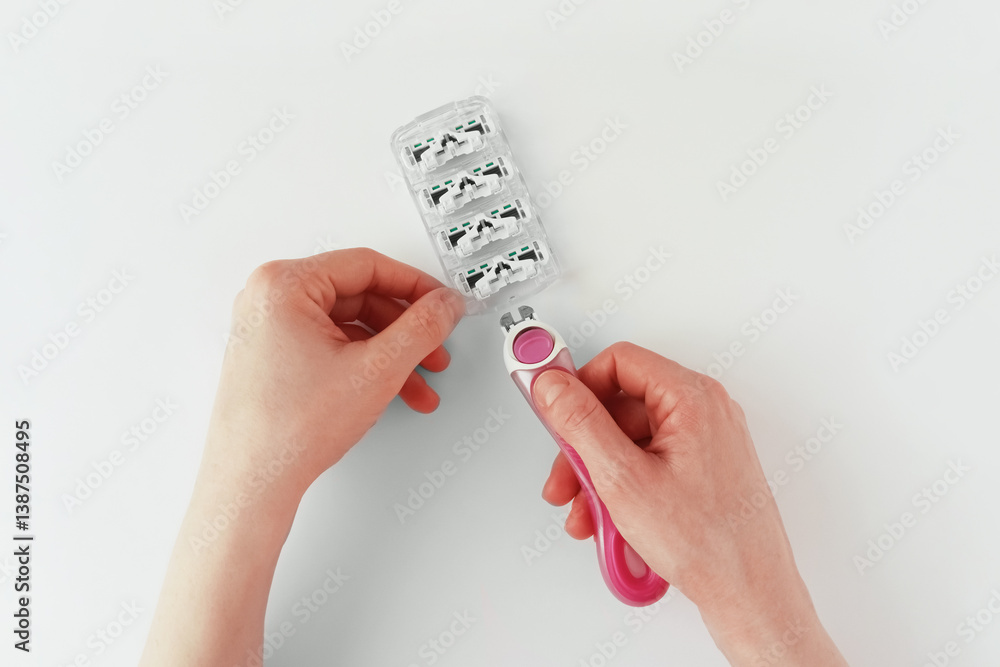 Pink razor in hands of Caucasian woman. Replacing blade cartridge for ...