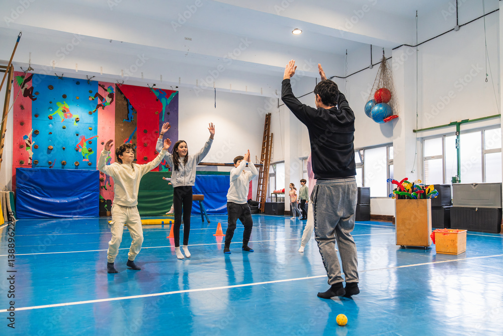 Students jumping and raising their arms, following their gym teacher's ...