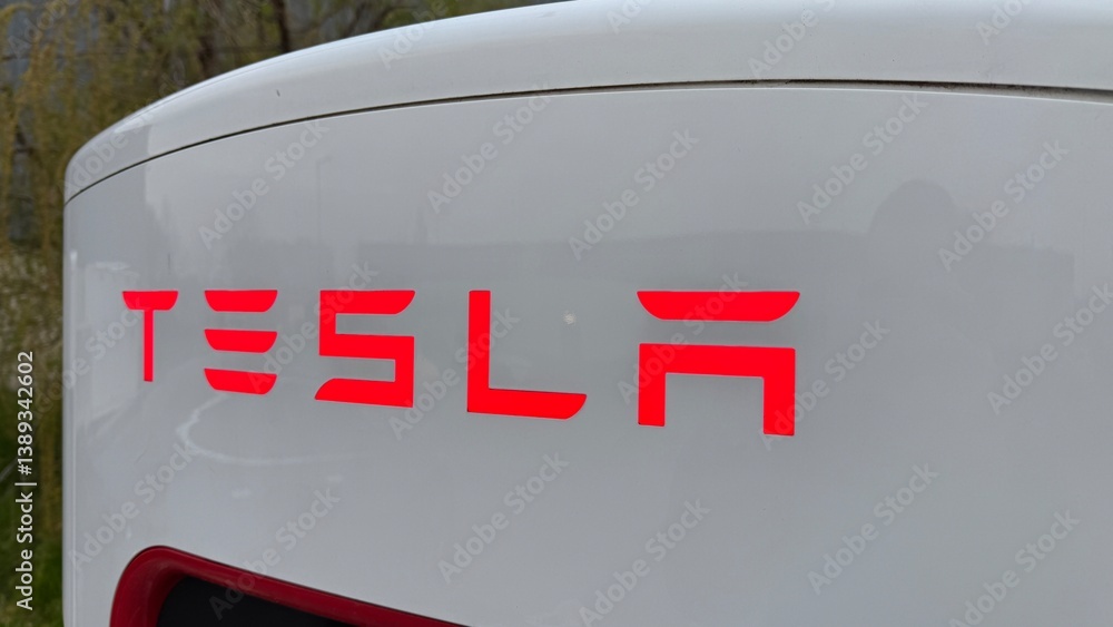 Red Tesla logo on sleek white charging station, symbolizing eco ...