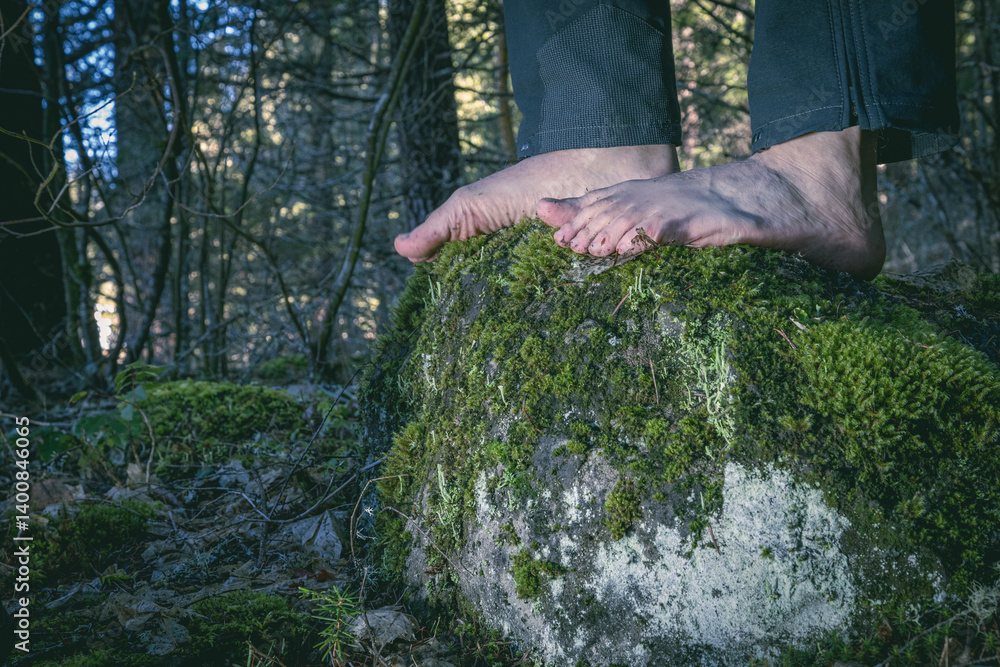 Human feet of an adult male walking barefoot in a forest as a form of ...