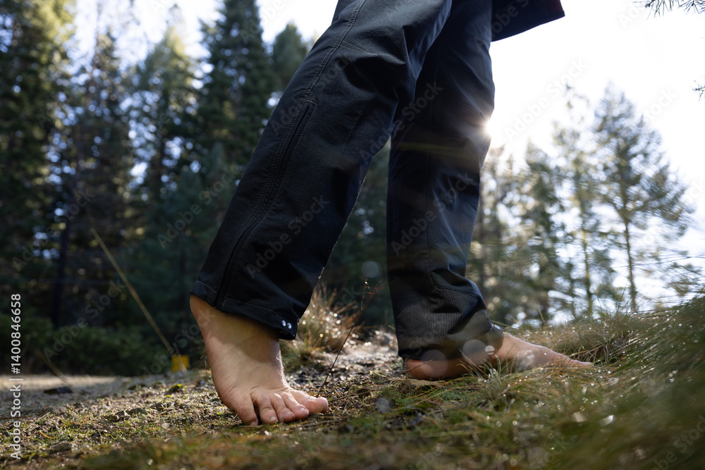 Human feet of an adult male walking barefoot in a forest as a form of ...